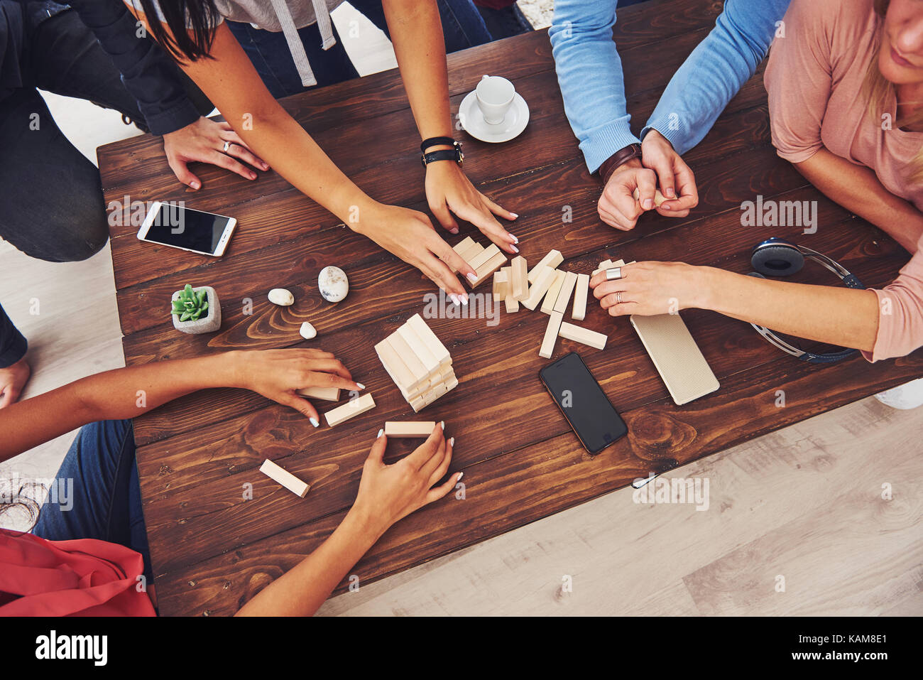 Top view creative photo of friends sitting at wooden table. Friends ...