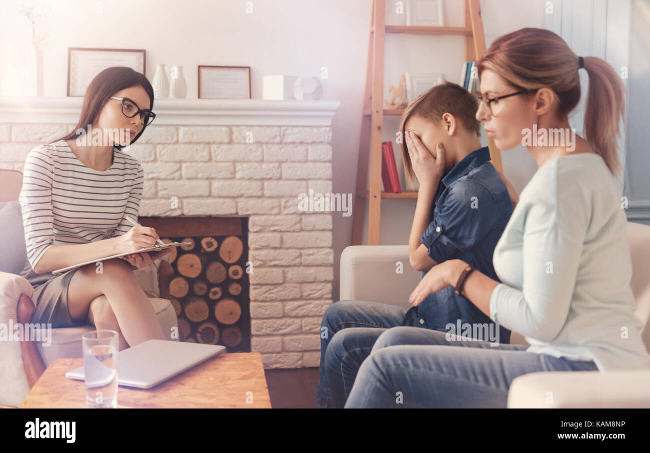 Professional psychologist talking with a caring mother and her son ...