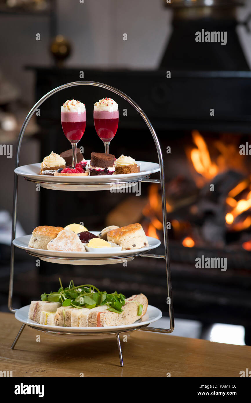 Afternoon tea platter served in front of a roaring orange warm log fire ...