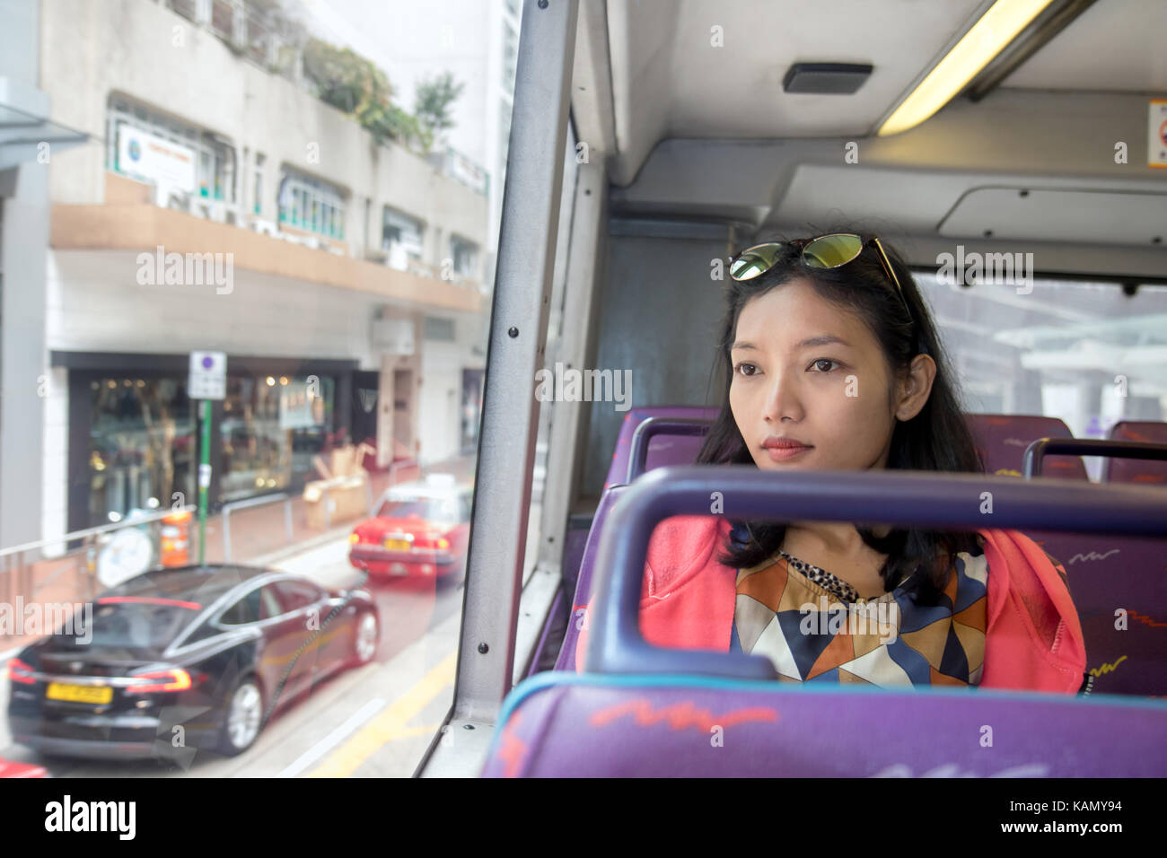 Young woman travels with a double-decker bus in the city center. The ...