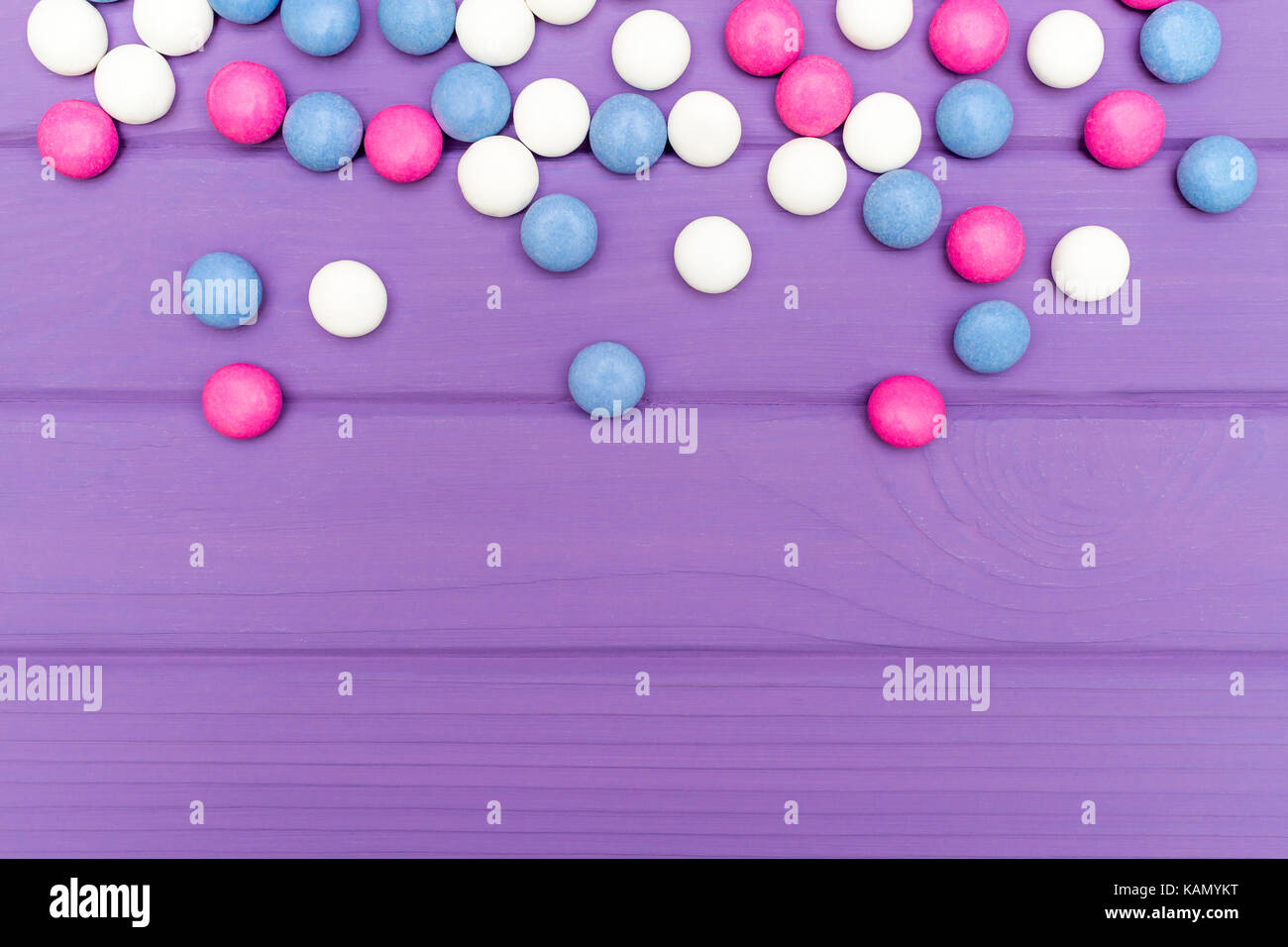 Colored chocolate coated candy on wooden background Stock Photo - Alamy