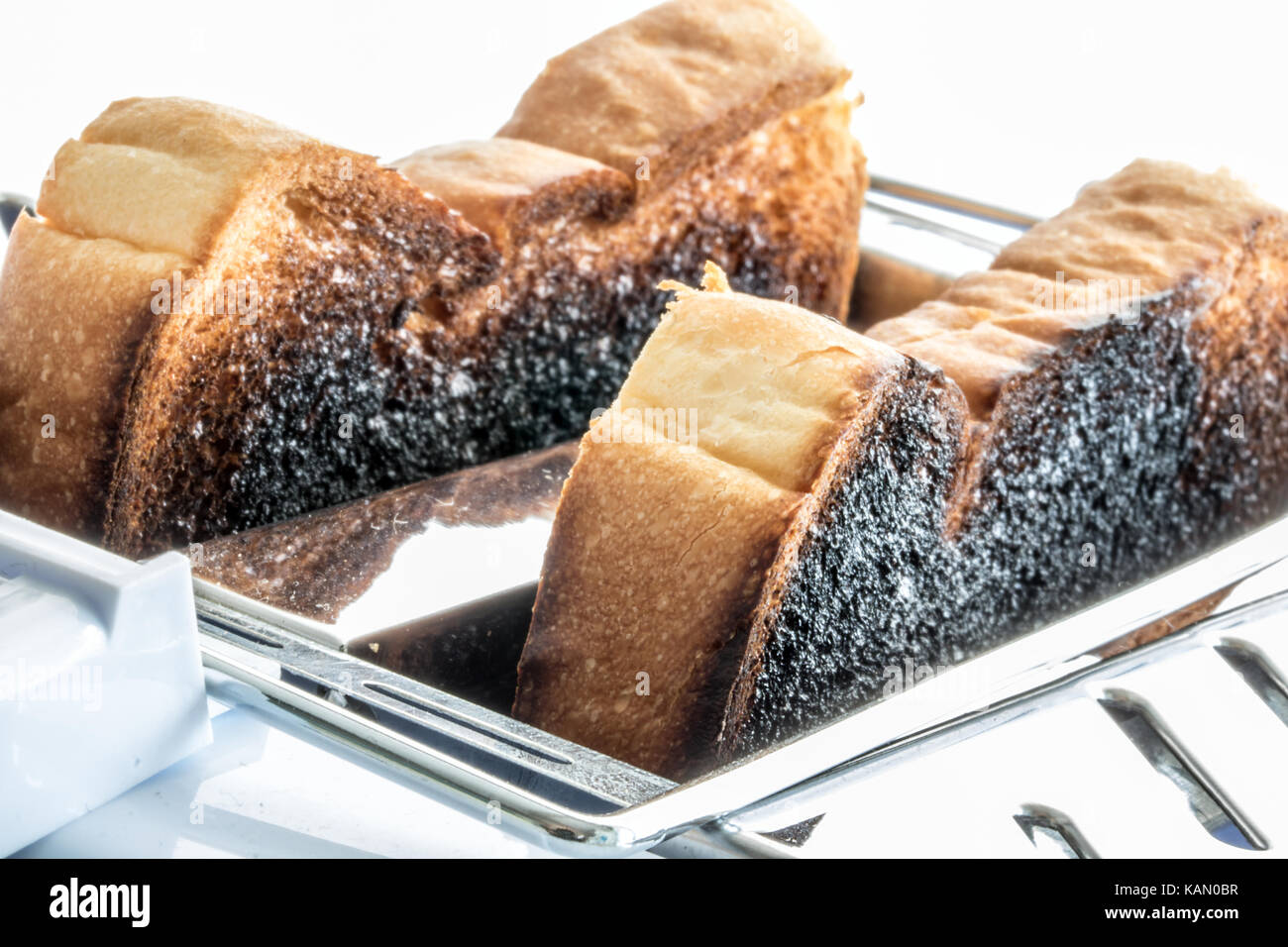 Burnt toast in a toaster. Fried toast slices inside the toaster. A ...