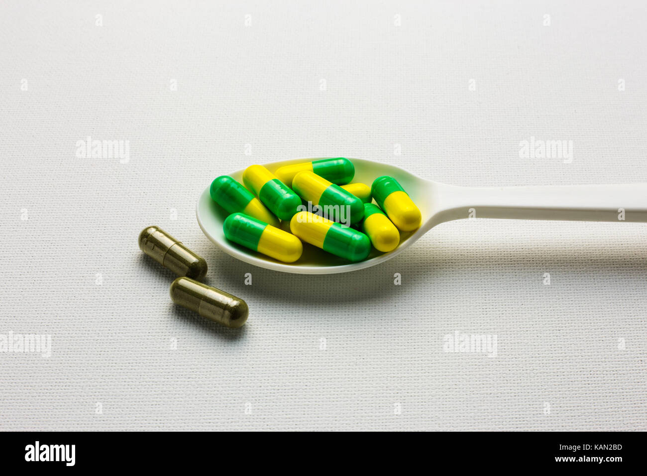 Many capsules pills on a spoon on white canvas background Stock Photo ...