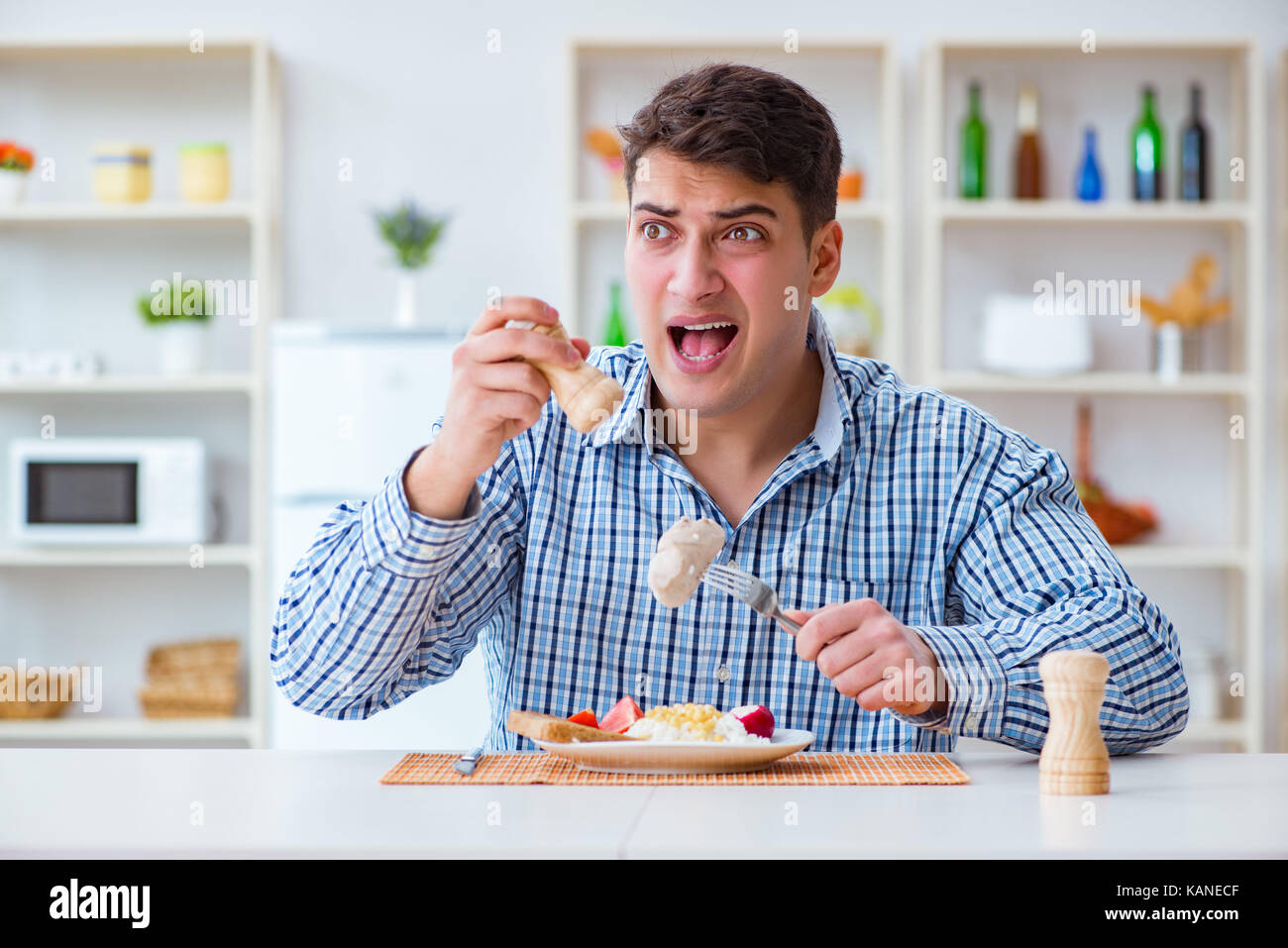 Man eating tasteless food at home for lunch Stock Photo - Alamy