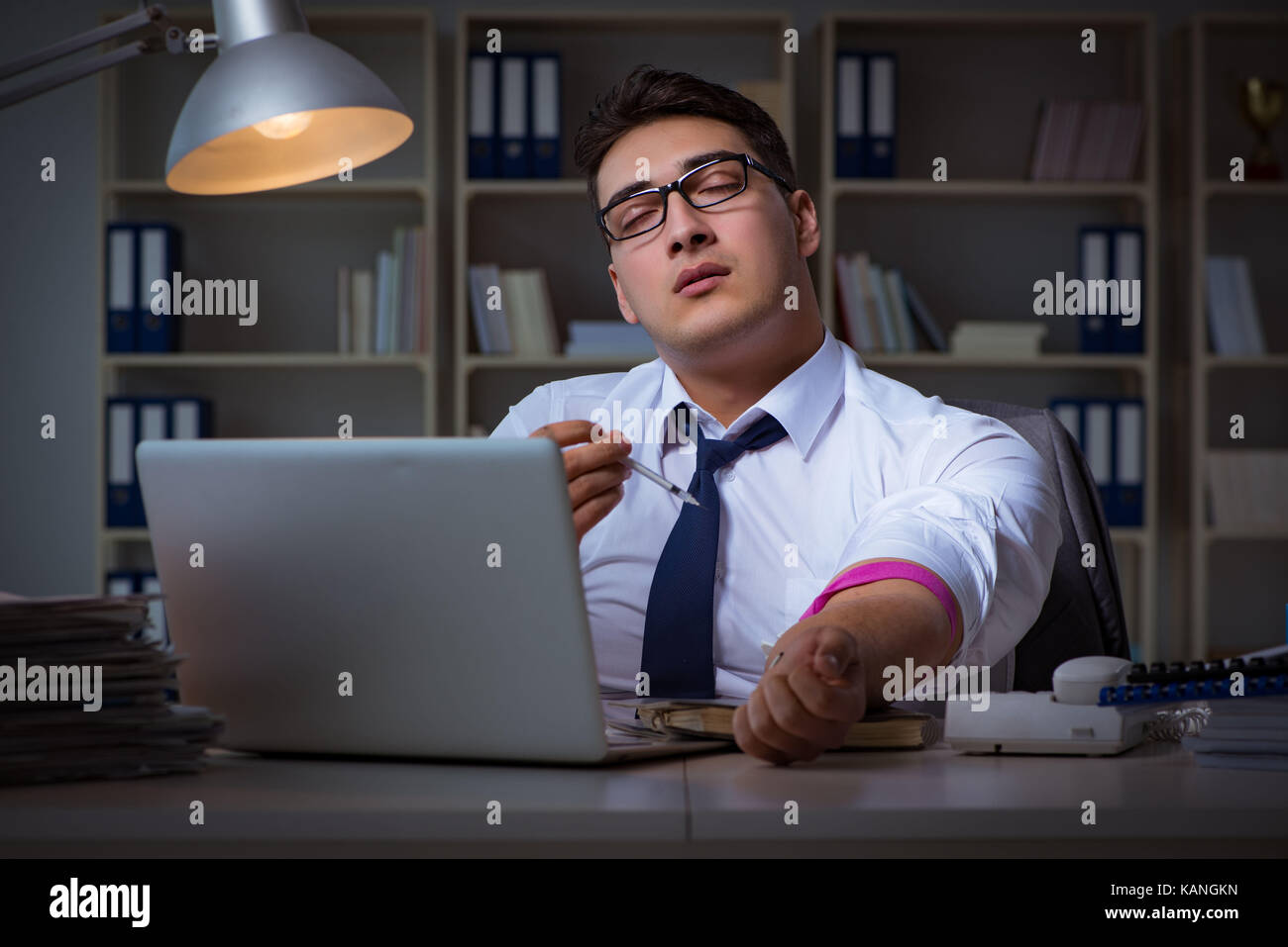 Businessman staying late in office for drugs Stock Photo - Alamy