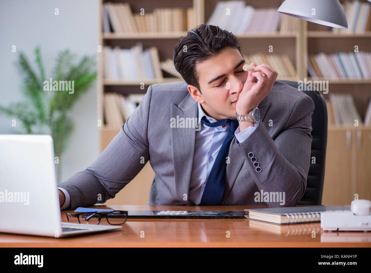 Drug addict businessman in the office Stock Photo - Alamy