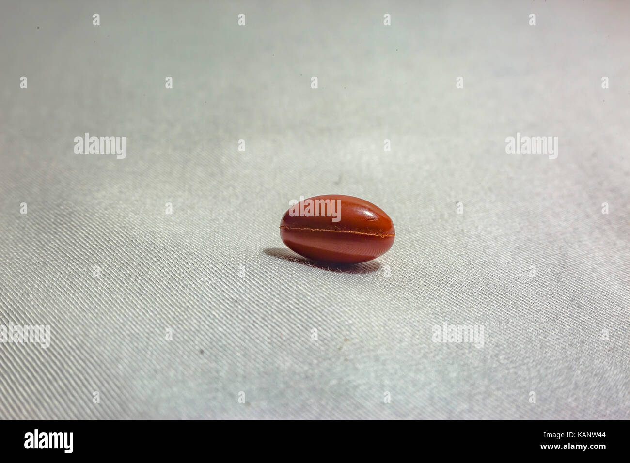 One pill on a white background with fabric texture shot in studio ...