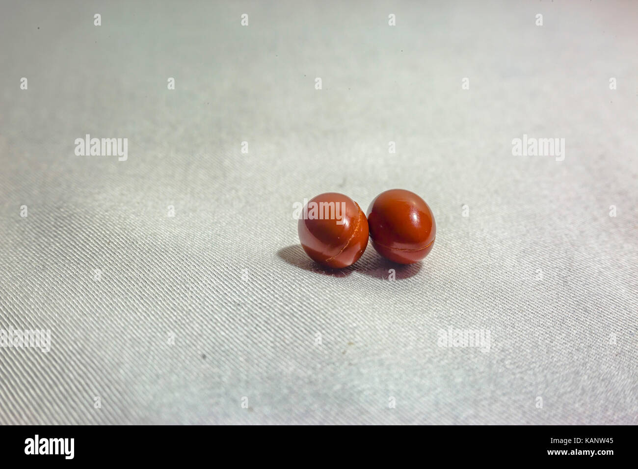 Pair of pills on a white background with fabric texture shot in studio ...
