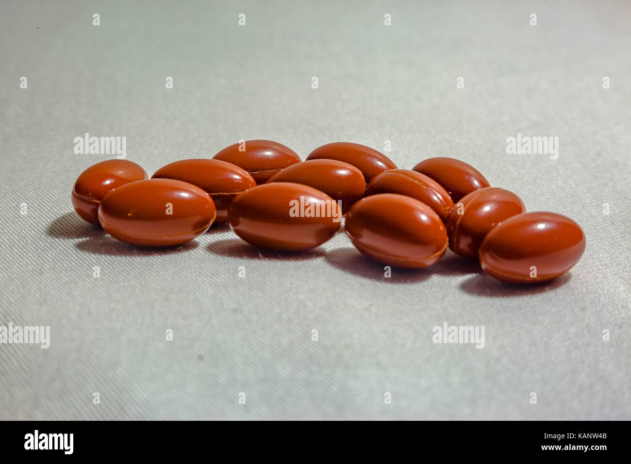 Pills on a white background with fabric texture shot in studio. Orange ...