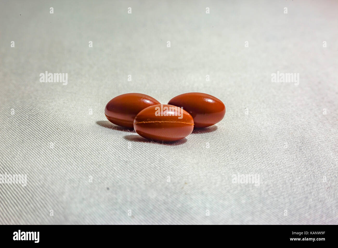 Three pills on a white background with fabric texture shot in studio ...