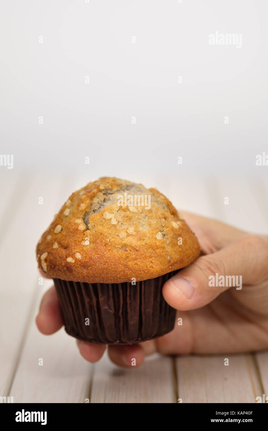 Hands holding a blueberry muffin look delicious. Select focus. Vertical ...