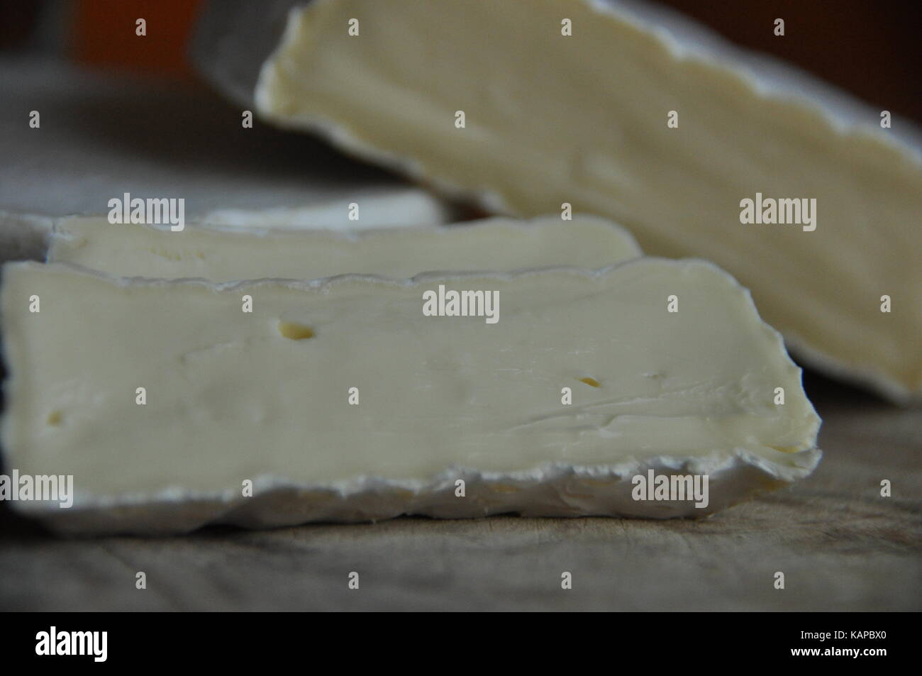 Cheese sliced on the board. Soft and fluffy Stock Photo - Alamy