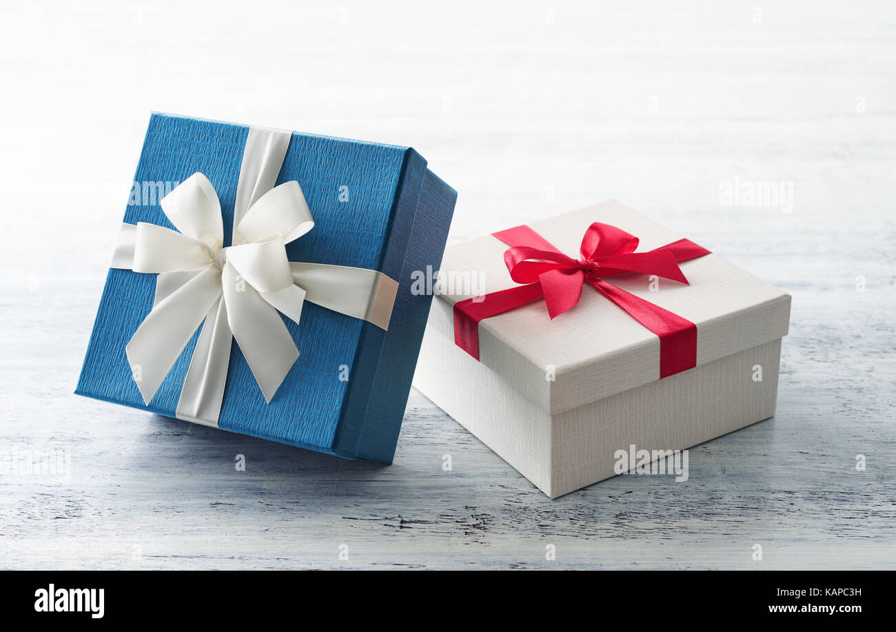 Blue and white gift box with ribbon on white painted wood background ...