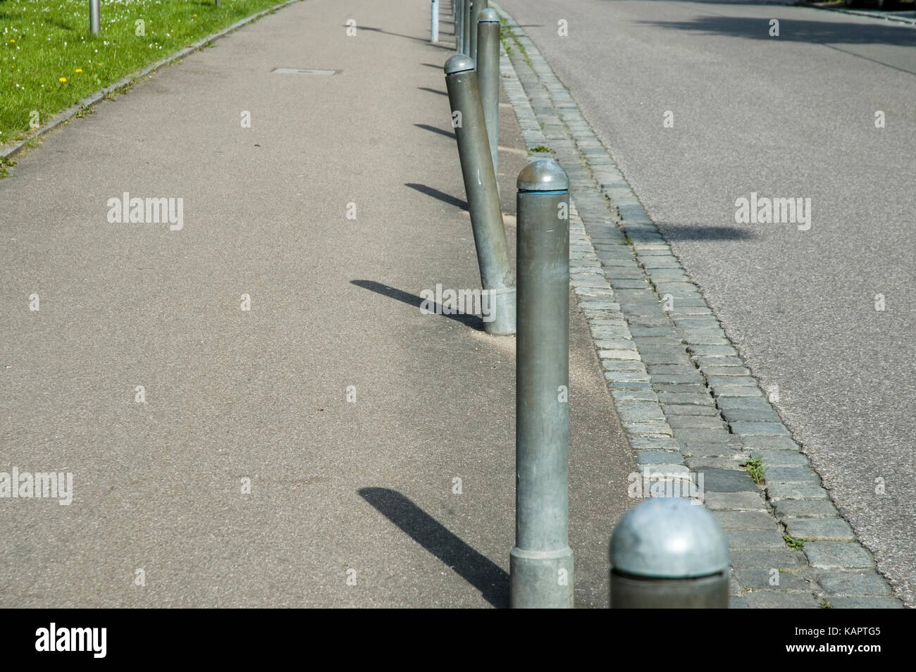 metal posts as border of a sidewalk Stock Photo - Alamy