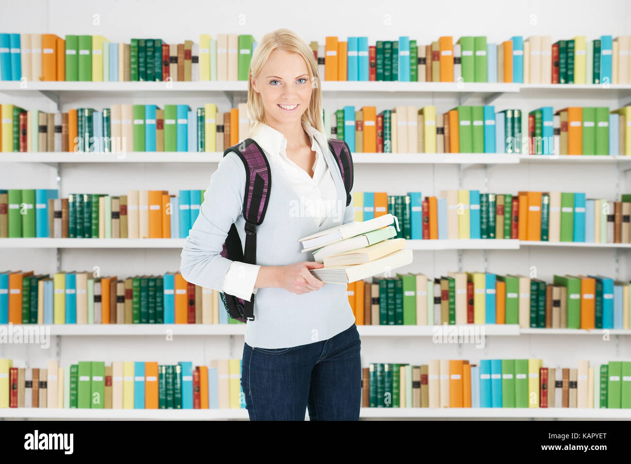 Portrait of smiling female university student holding file while ...