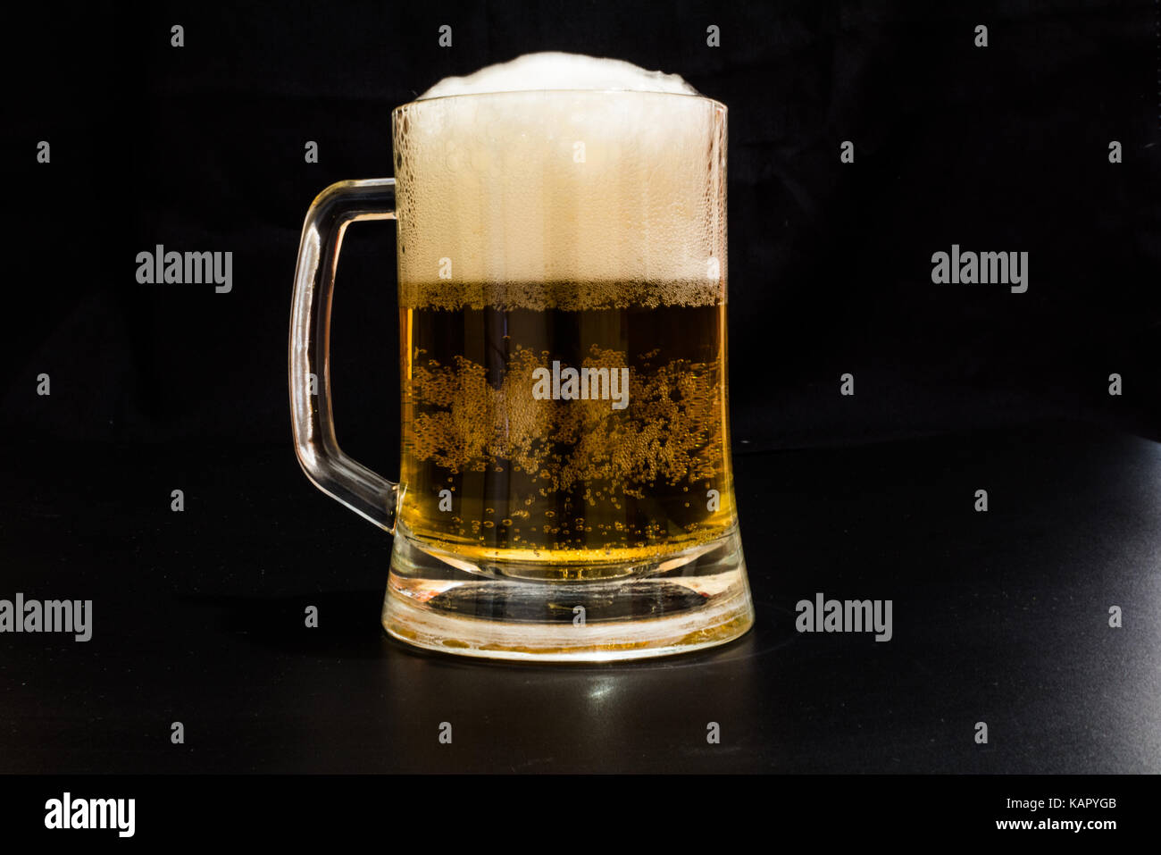 A mug of beer with foam on a black background Stock Photo - Alamy