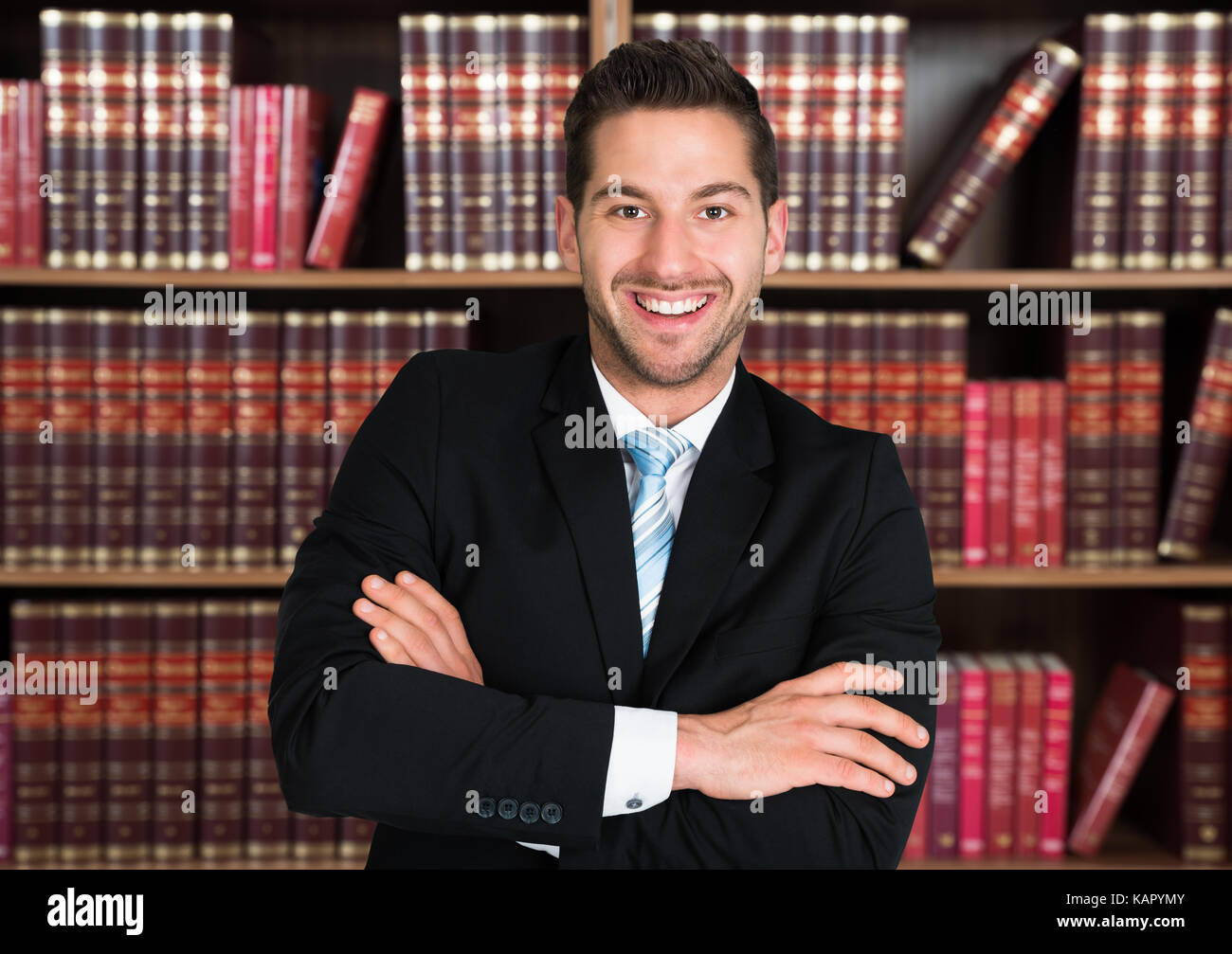 Portrait of confident male lawyer standing arms crossed against ...