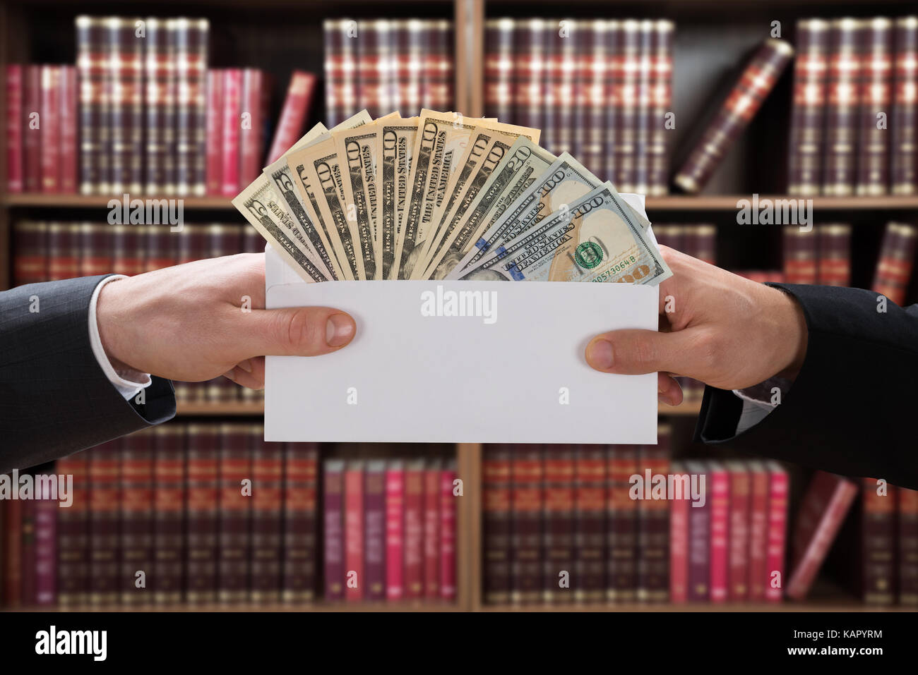 Cropped image of man's hands passing bribe to judge in envelope at ...