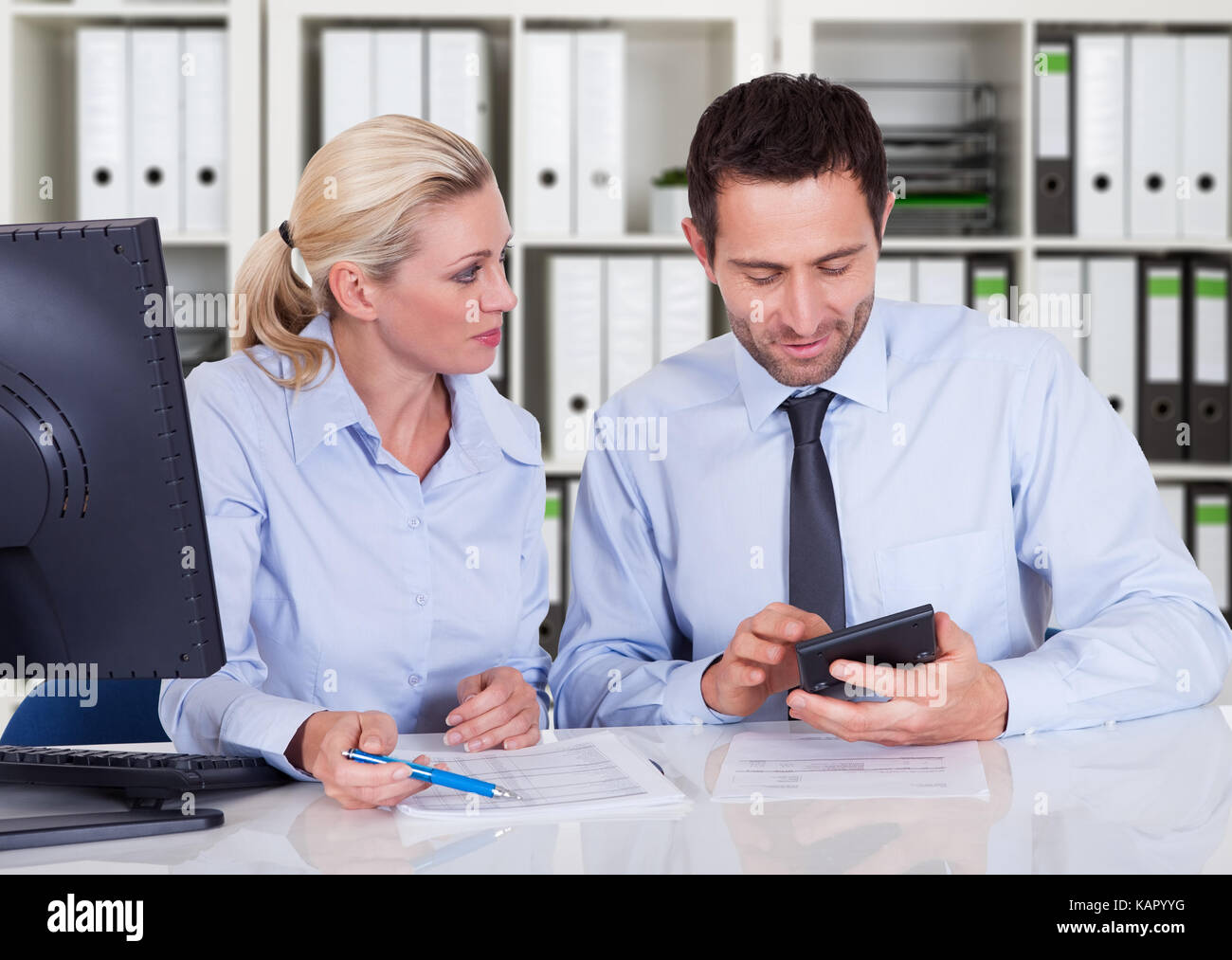 Male and female accountants calculating finance together at desk in ...