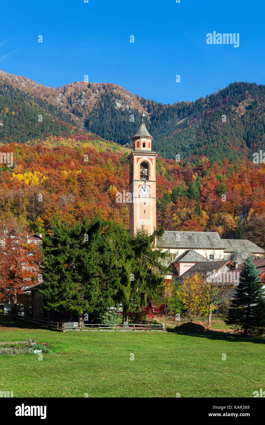Green lawn, parish church belfry and colorful autumnal trees on ...