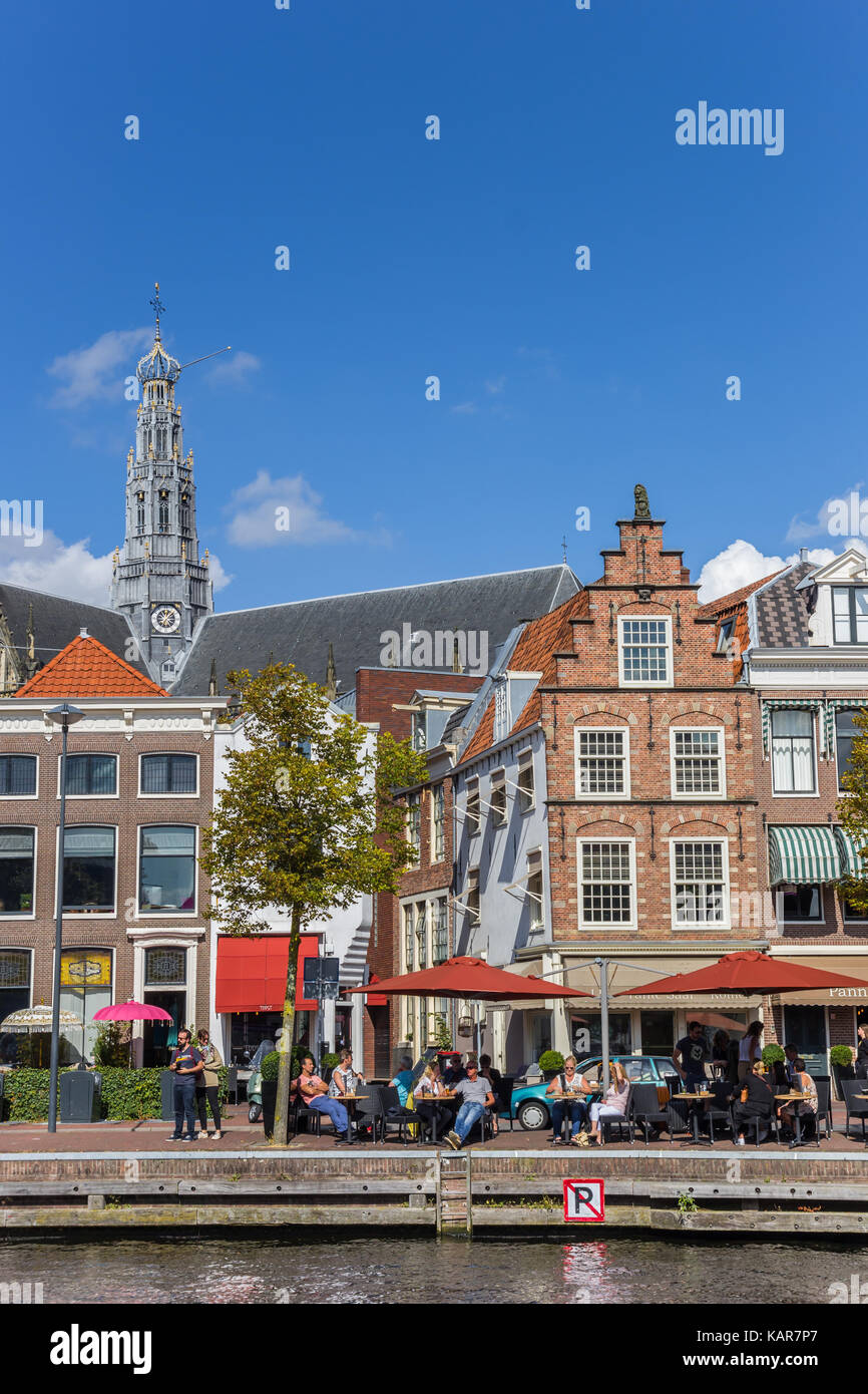 People enjoying the sun at a historic canal in Haarlem, Netherlands ...