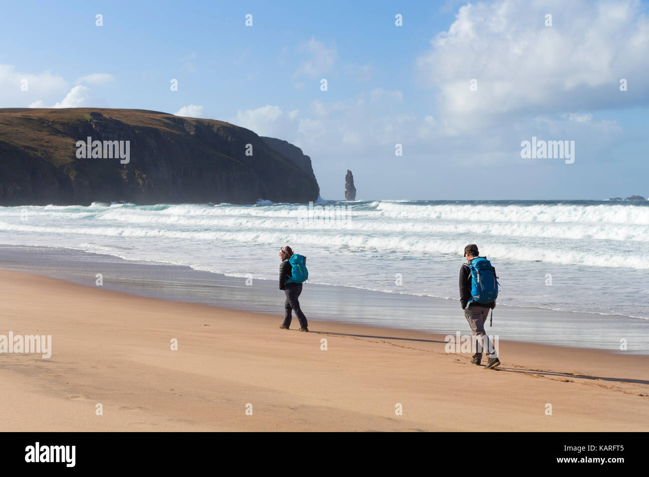 Two People Walking Along the Coast at Sandwood Bay with the Sea Stack ...