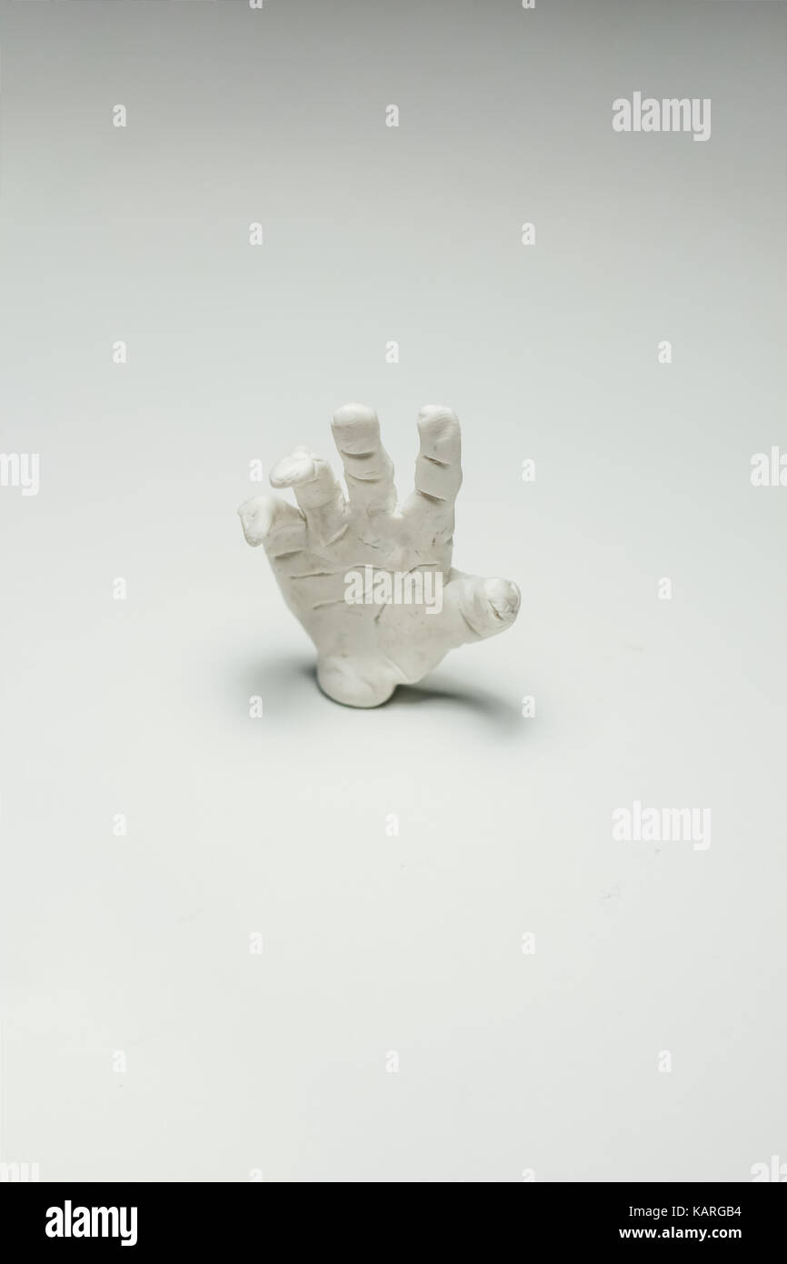 A palm, made of clay, reaching for help, with the fingers half-opened ...