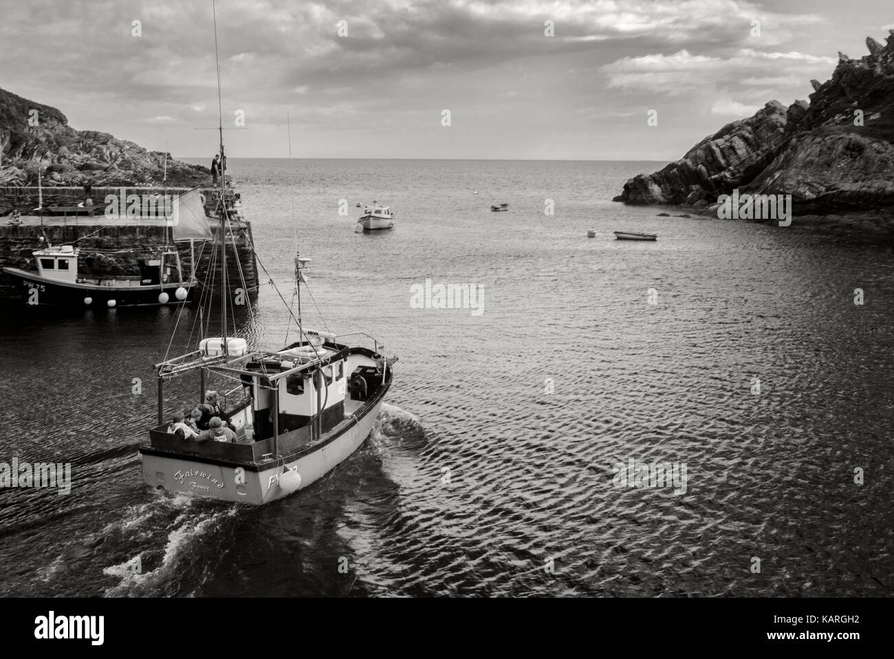 Tourist boat leaving harbour heading out to see past cliffs hi-res ...