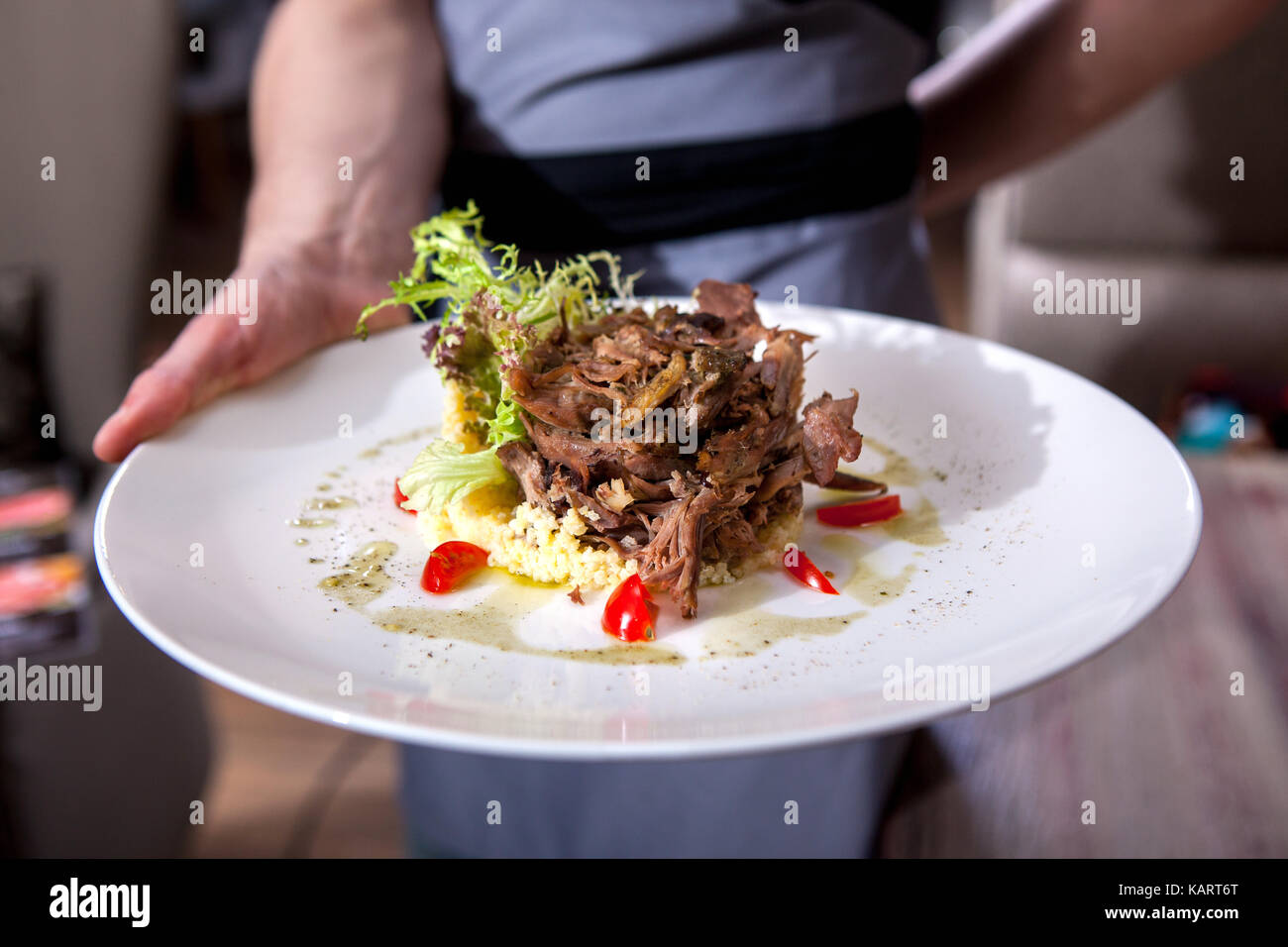 Waitress is carrying a plate with meat dish Stock Photo - Alamy