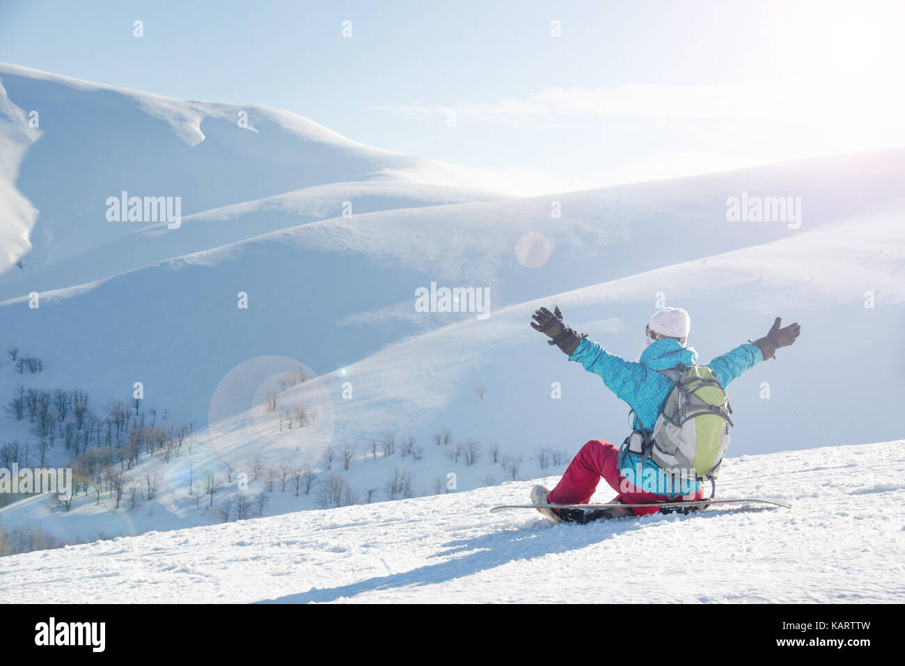 Young woman with snowboard sitting on the slope of hill Stock Photo - Alamy