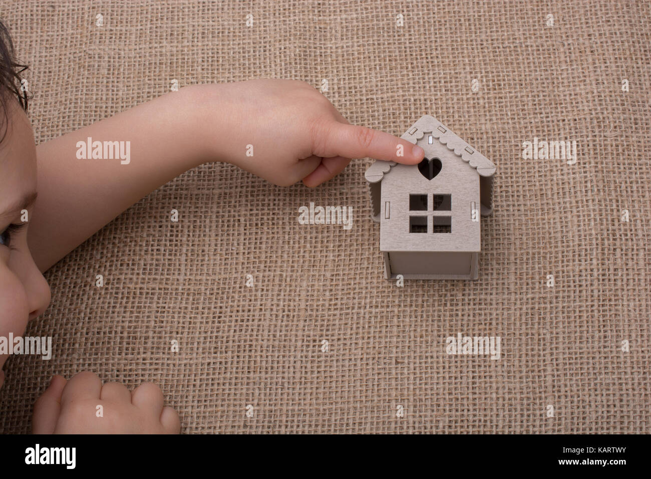 Child holding a model house on a linen canvas Stock Photo - Alamy
