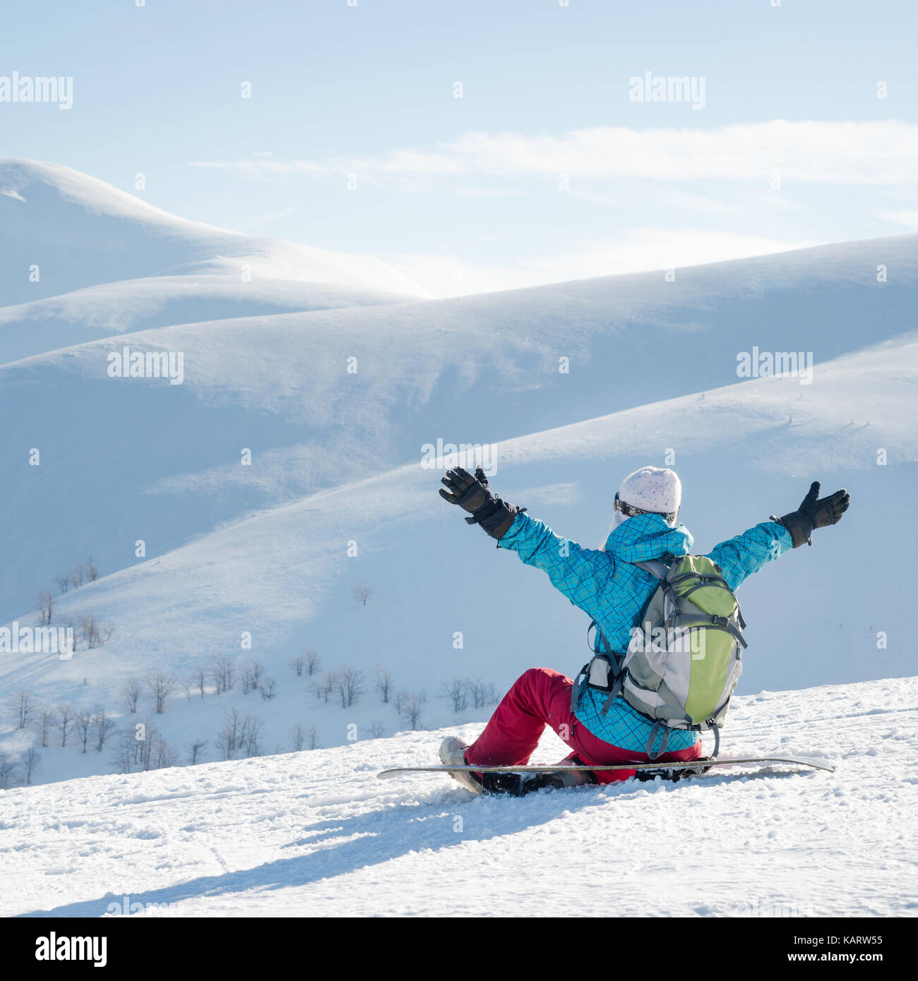 Young woman with snowboard sitting on the slope of hill Stock Photo - Alamy