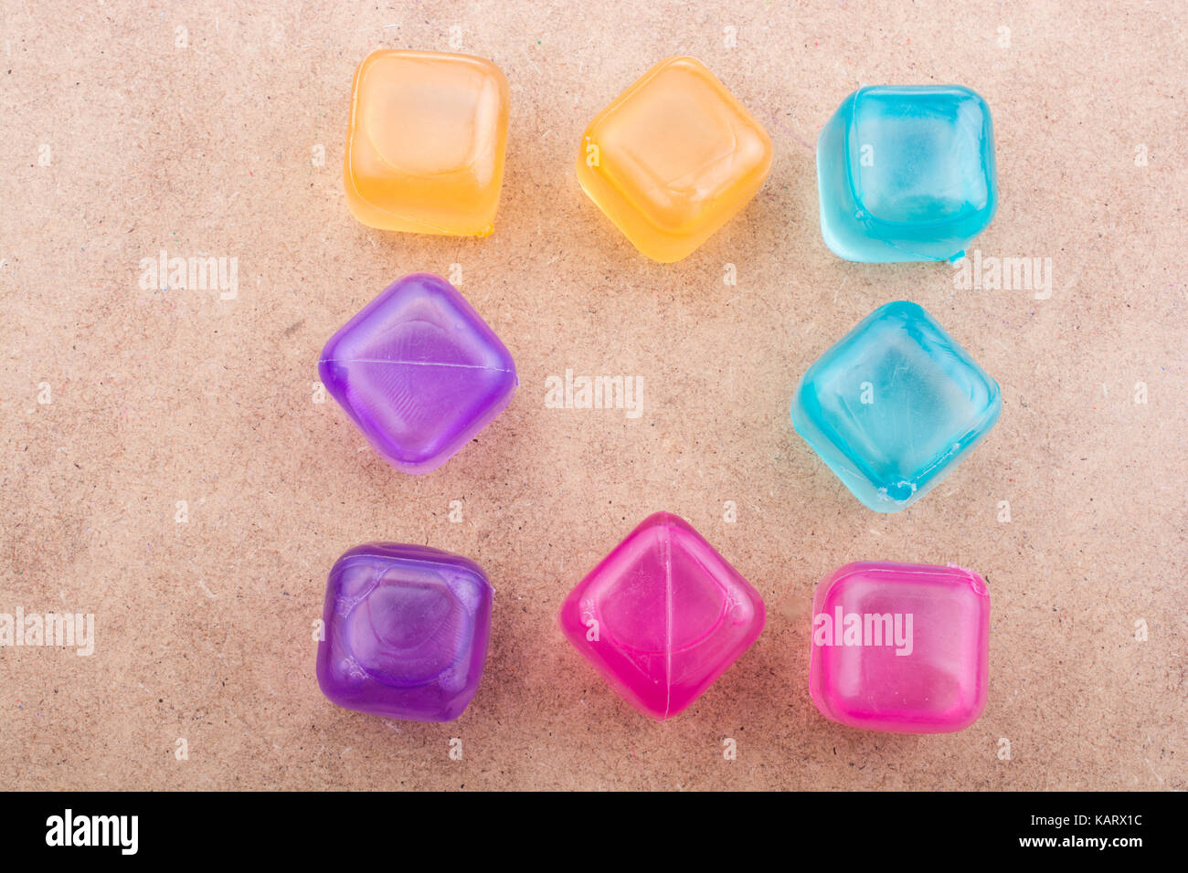 Fake colorful ice cubes on a brown background Stock Photo - Alamy