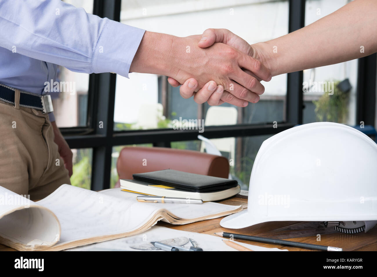 engineer handshaking for successful deal in construction plan. young ...