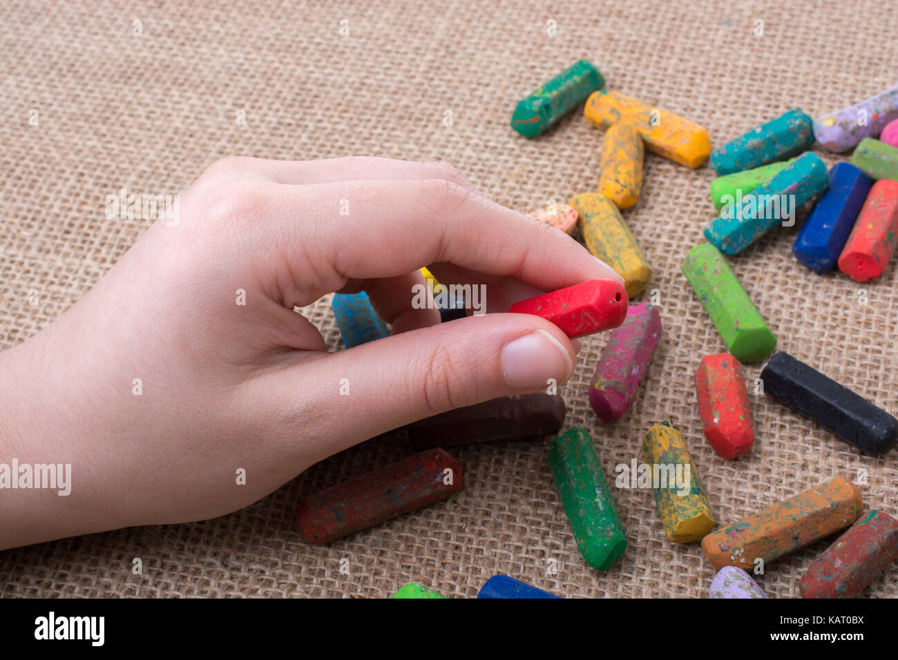 Used color crayons and a hand holding one Stock Photo - Alamy
