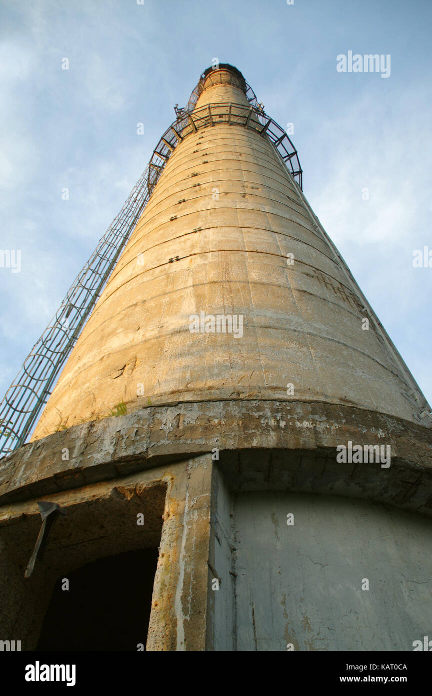Old concrete high chimney on cloudy sky background Stock Photo - Alamy