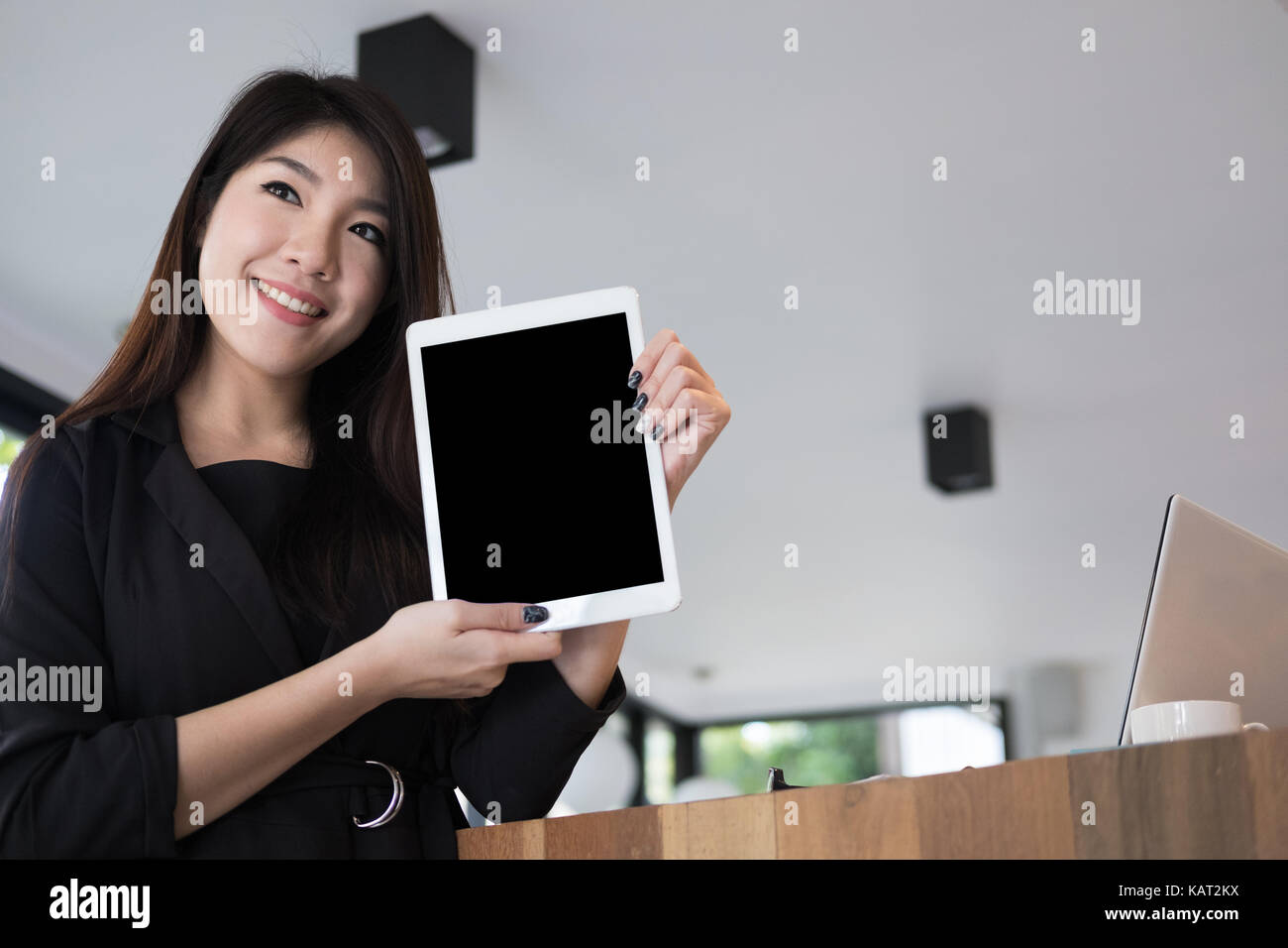 businesswoman hold digital tablet at workplace. young woman shows ...