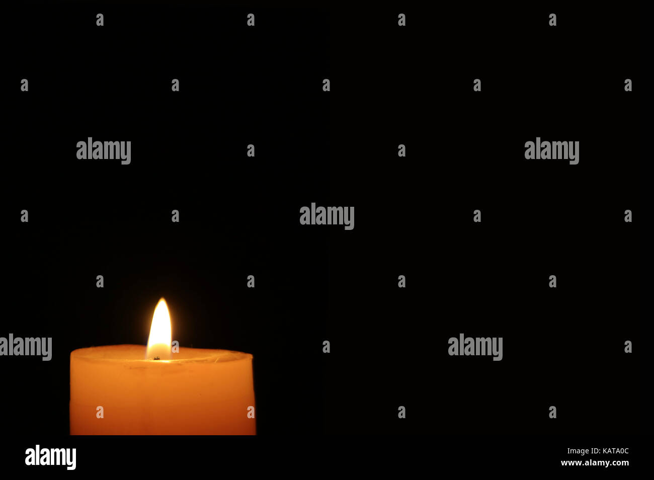 One shining orange color candle in the darkness Stock Photo - Alamy
