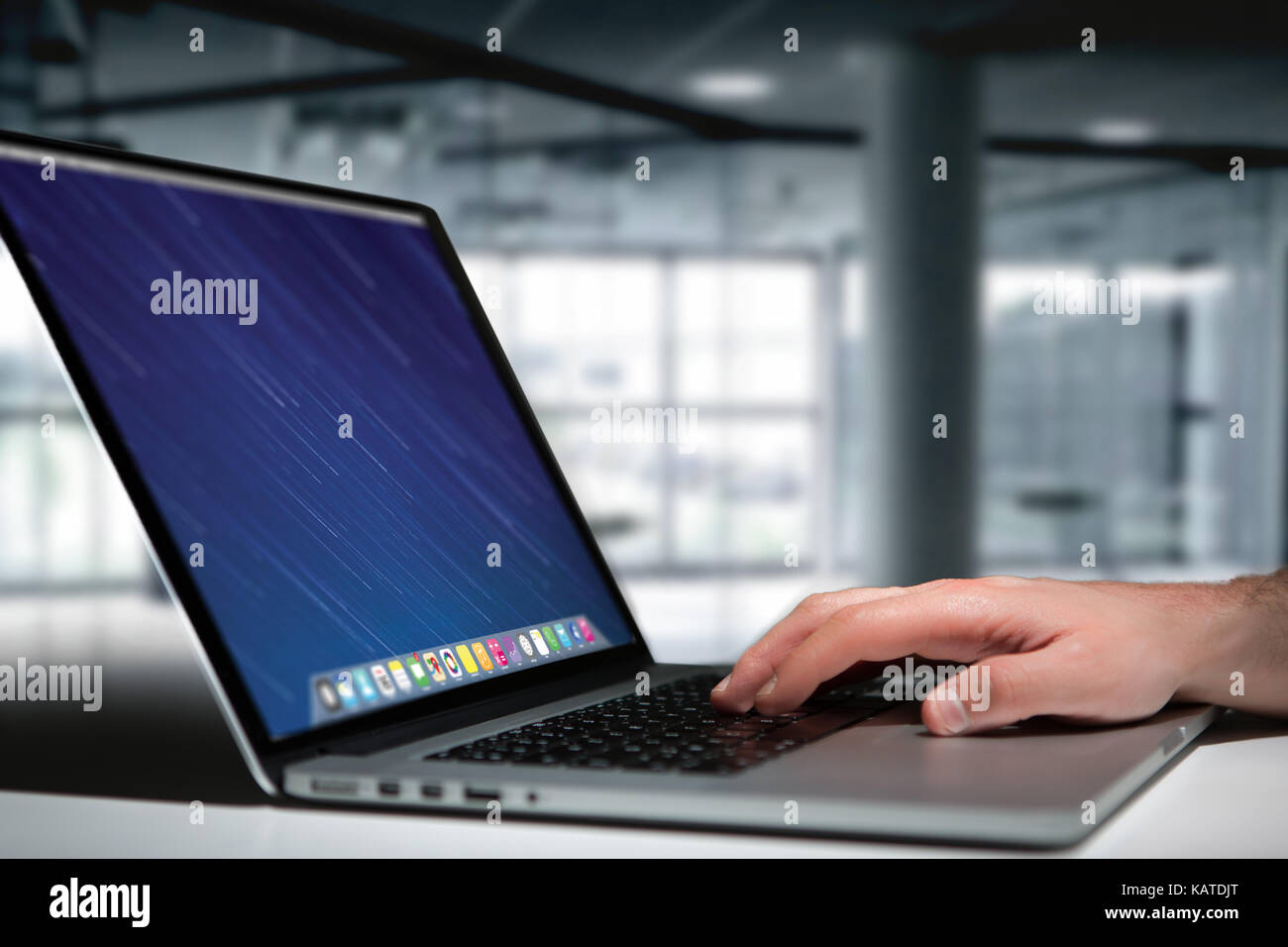 Hand typing on a keyboard of laptop with operating system screen on ...