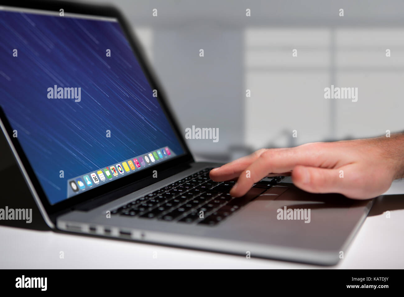 Hand typing on a keyboard of laptop with operating system screen on ...