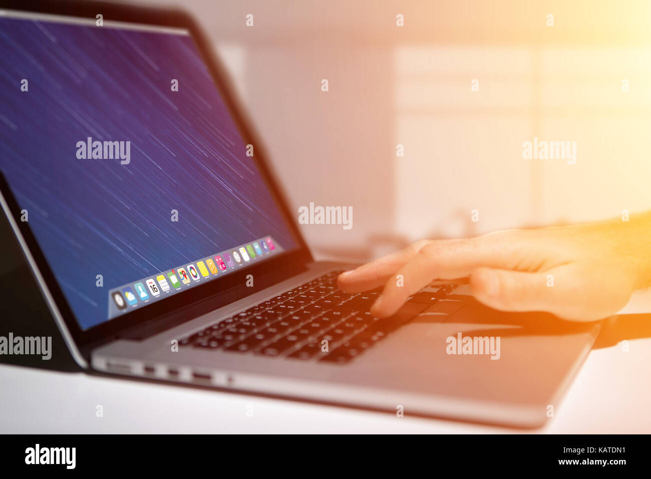 Hand typing on a keyboard of laptop with operating system screen on ...