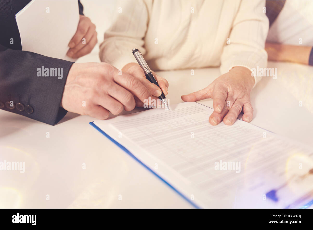 Old woman signing agreement hi-res stock photography and images - Alamy