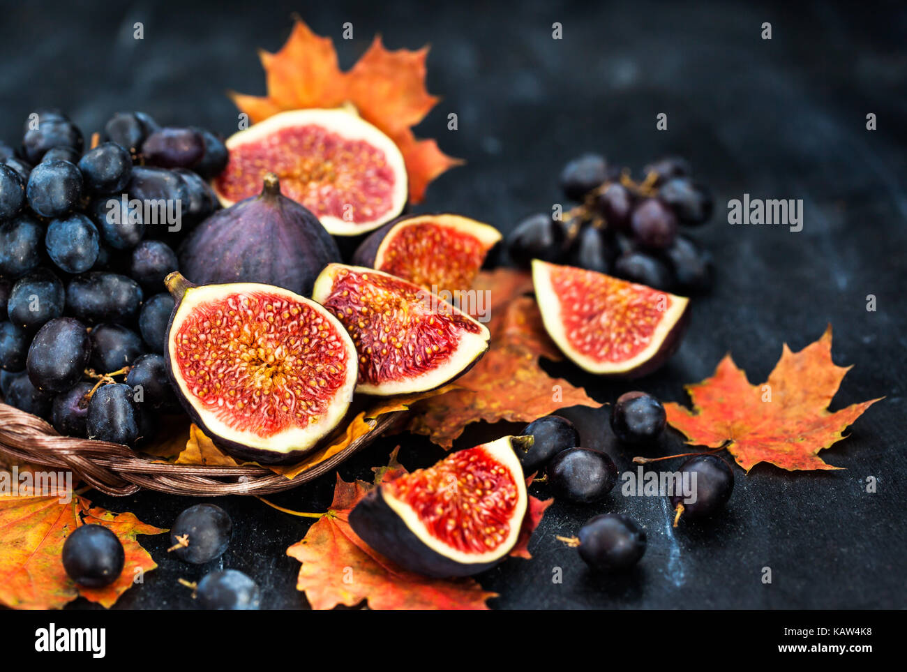 Autumnal fresh ripe figs and purple grape on dark background Stock ...