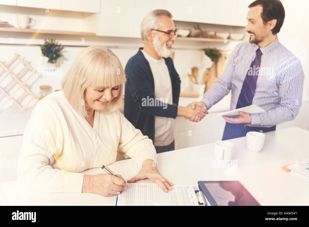 Cheerful aged woman signing papers Stock Photo - Alamy