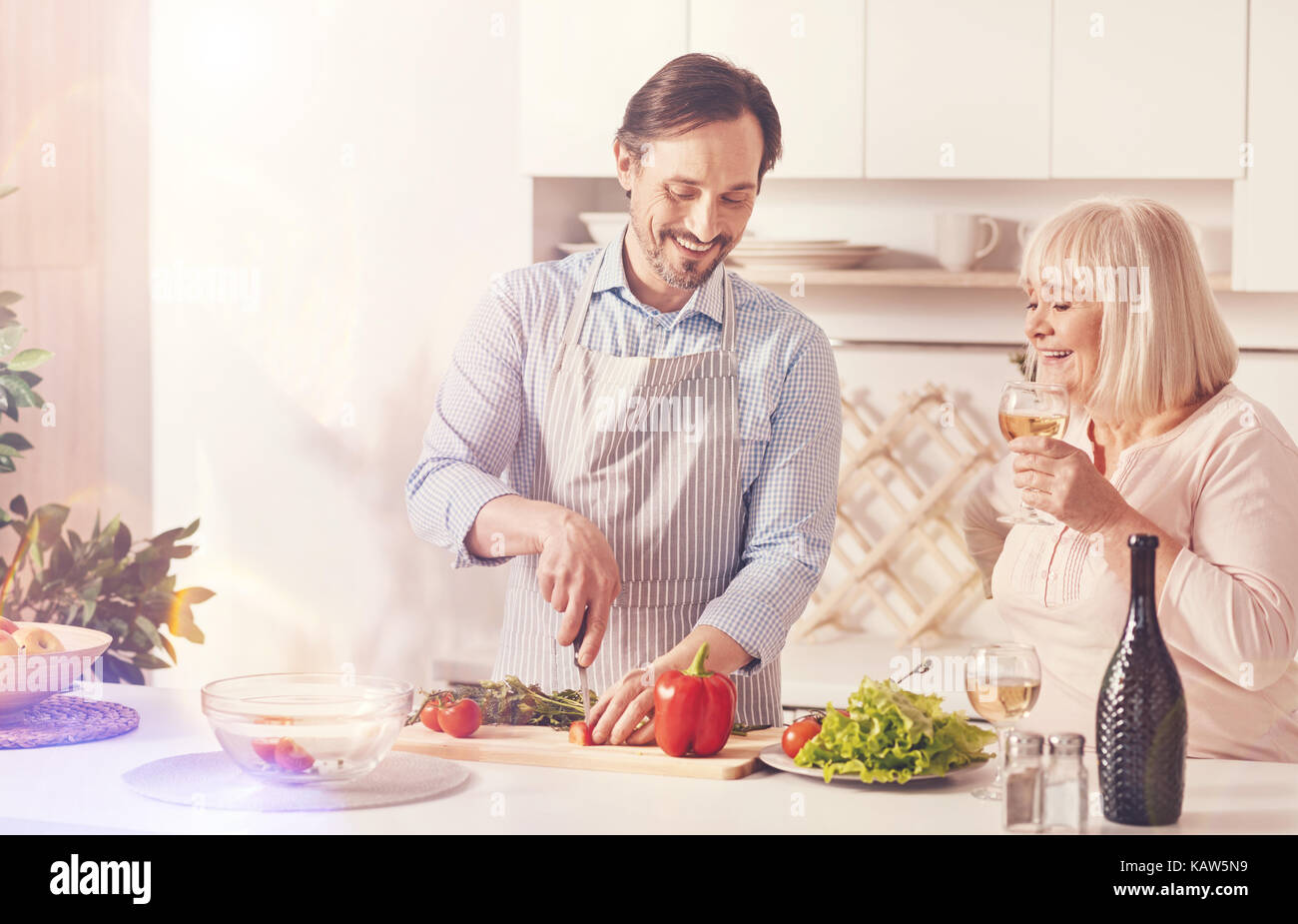 Cheerful adult man cooking with his aged mother Stock Photo - Alamy
