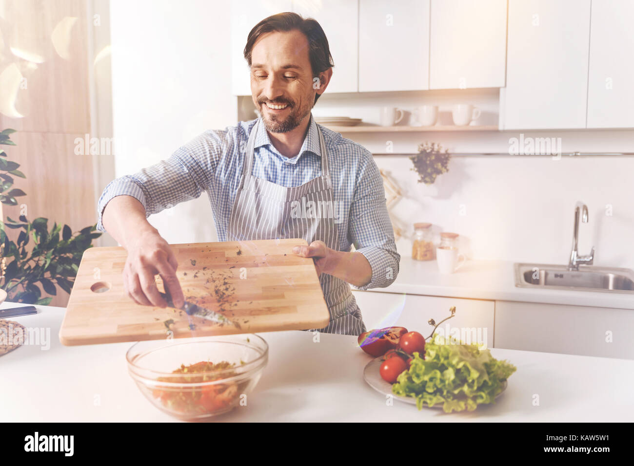 Smiling adult man cooking with inspiration Stock Photo - Alamy