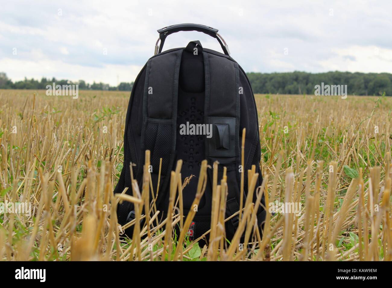 A small tourist backpack stands on the ground in the middle of a ...