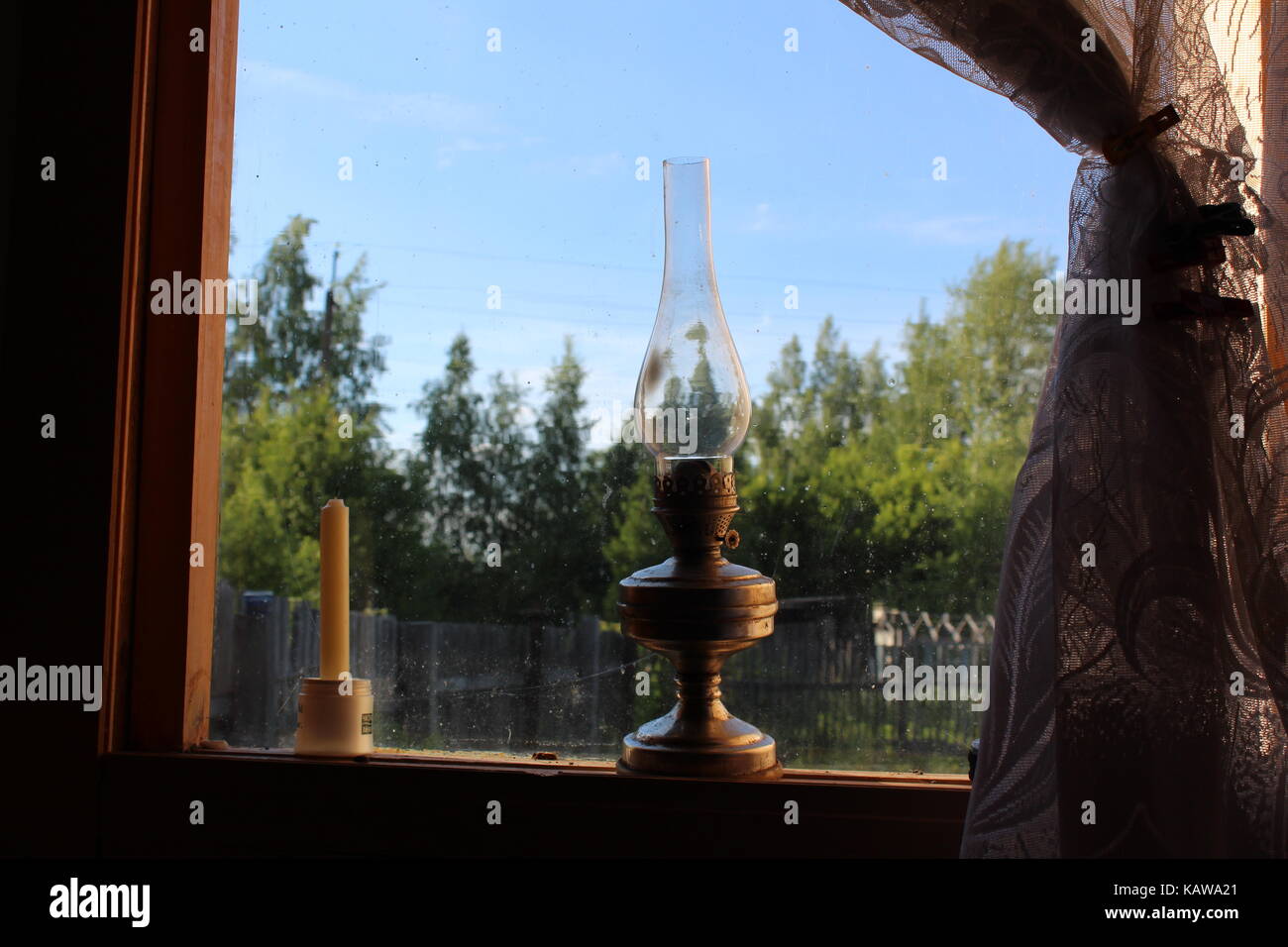 An old-fashioned kerosene lamp stands on a wooden window-sill Stock ...