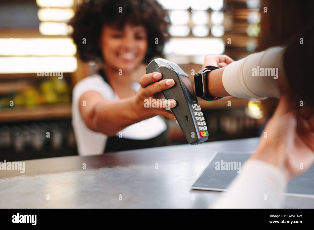 Customer making wireless or contactless payment using smartwatch. Store ...