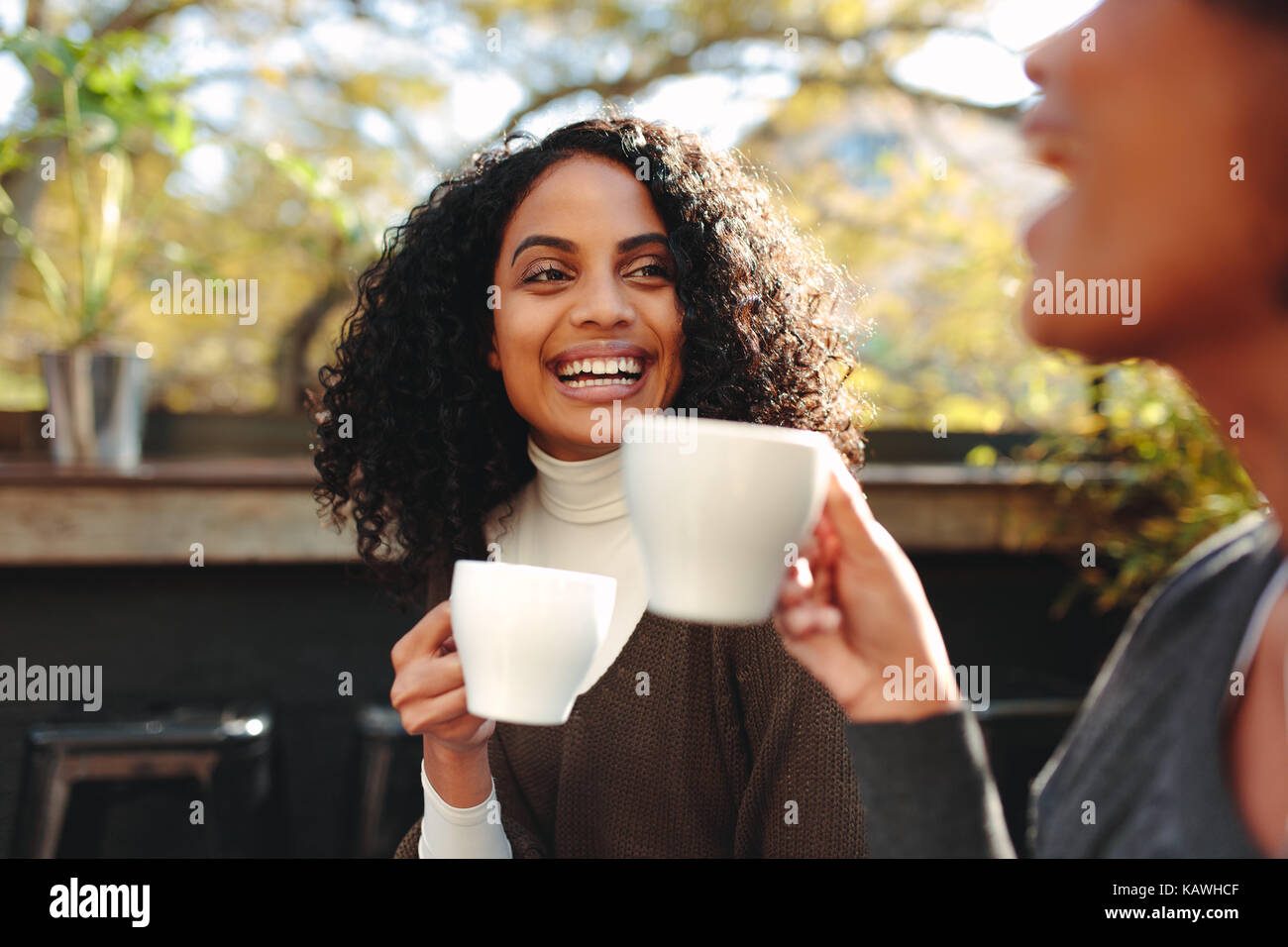 Two women laughing and having fun at a coffee shop. Friends chatting ...